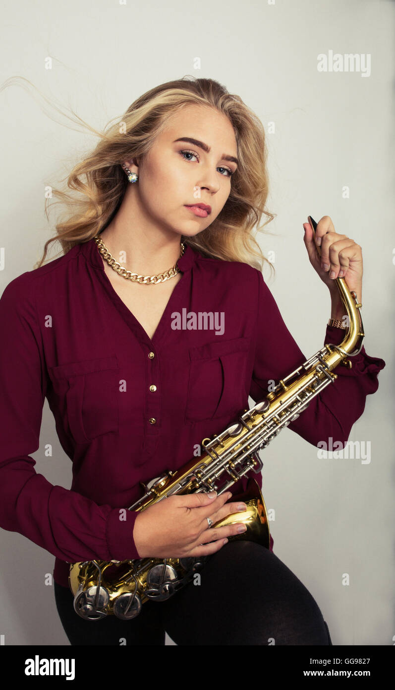 Blond teen girl holding saxophone Stock Photo - Alamy
