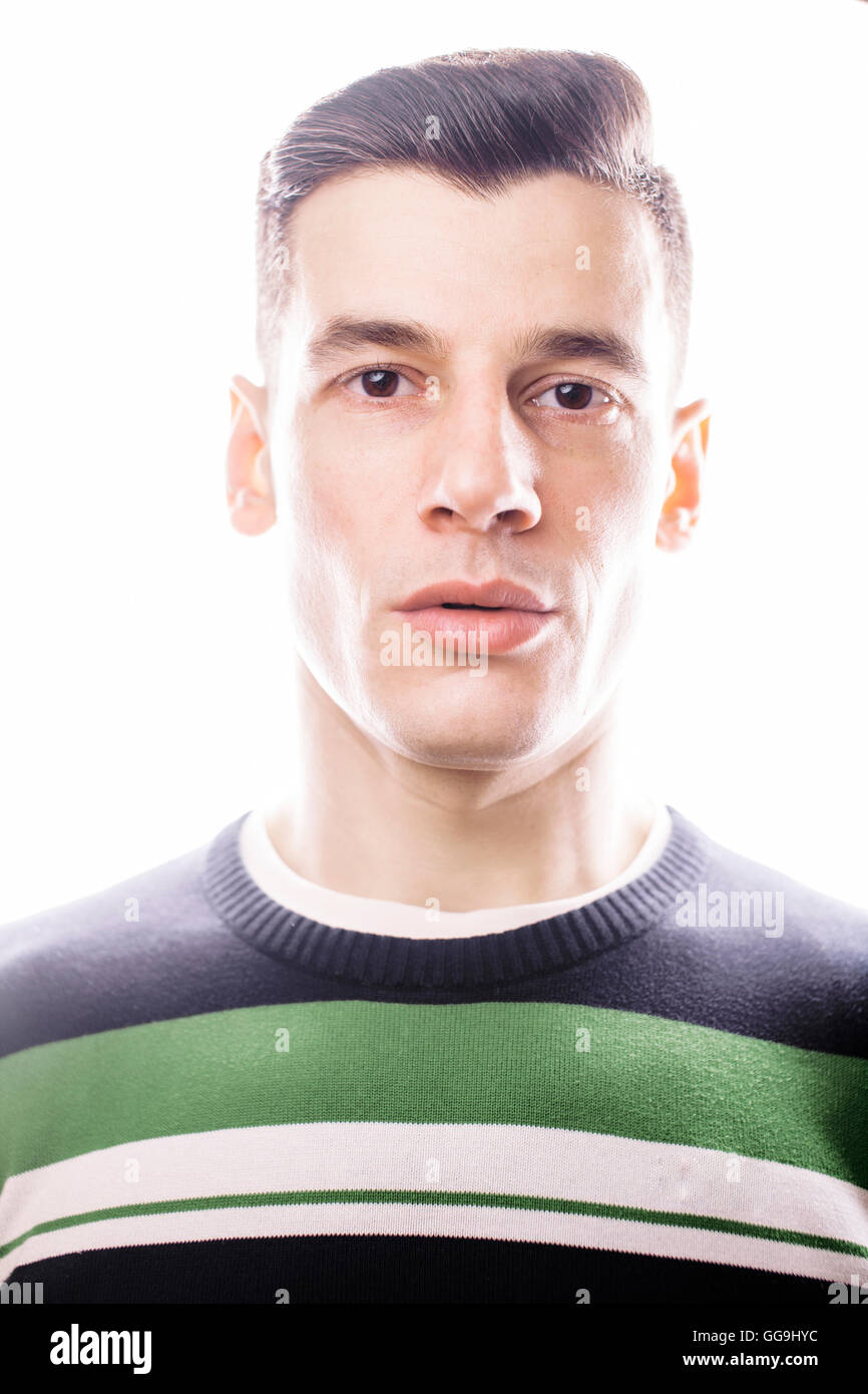 Portrait of a smart serious young man standing against white background ...