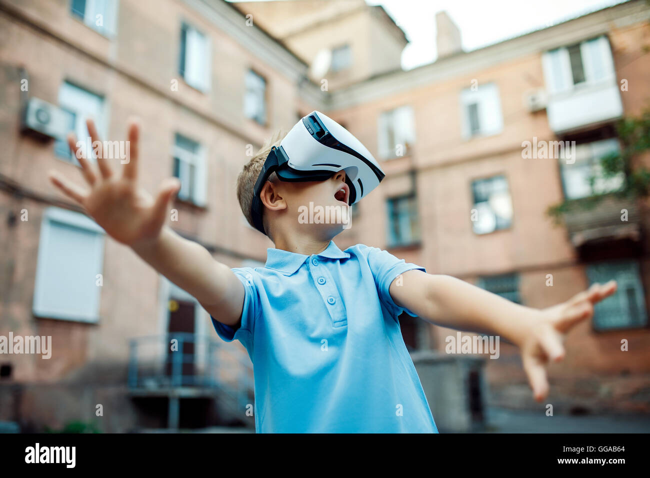 Fascinated little boy using VR virtual reality goggles. outdoor Stock ...
