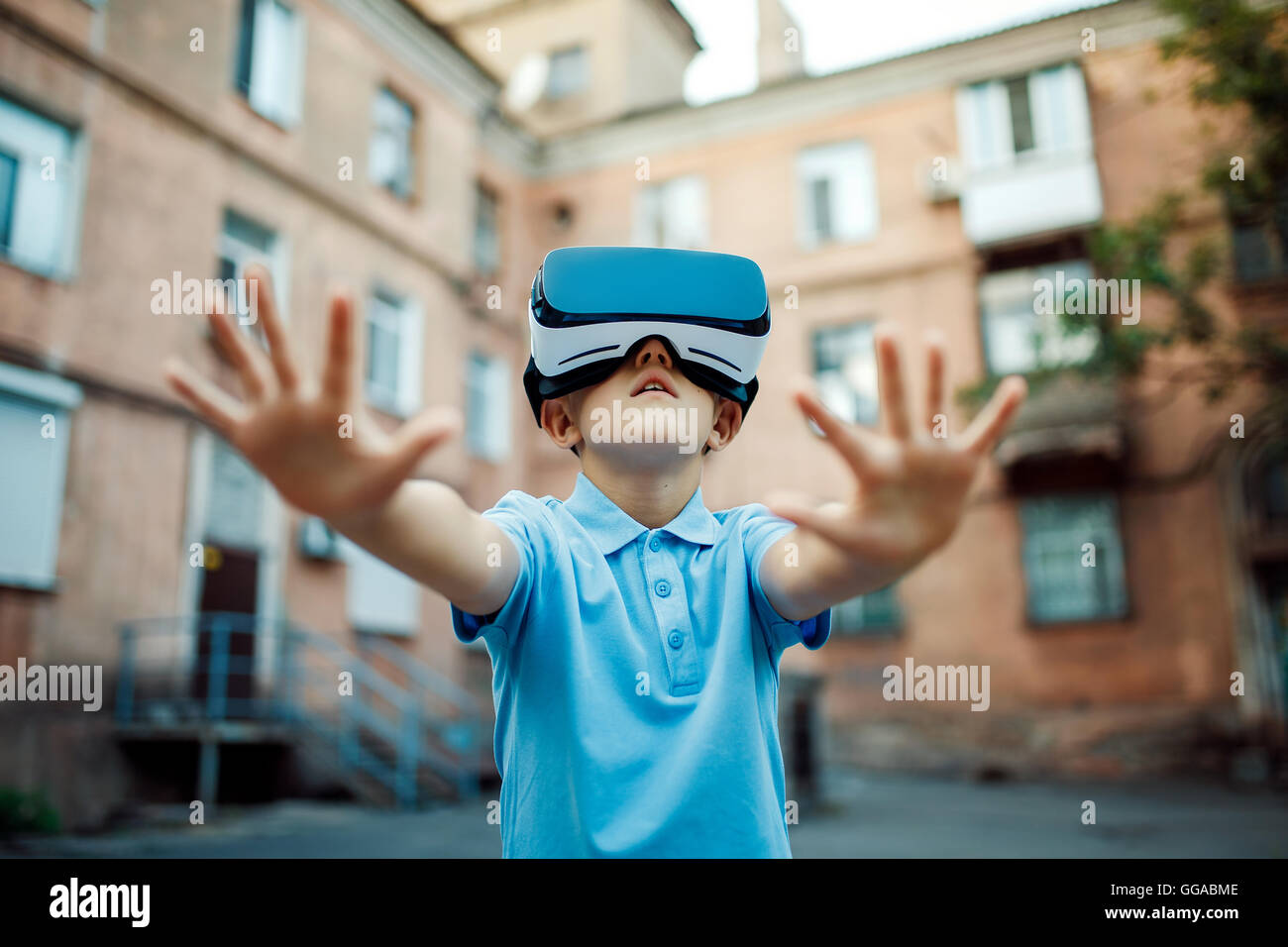 Fascinated little boy using VR virtual reality goggles. outdoor Stock ...