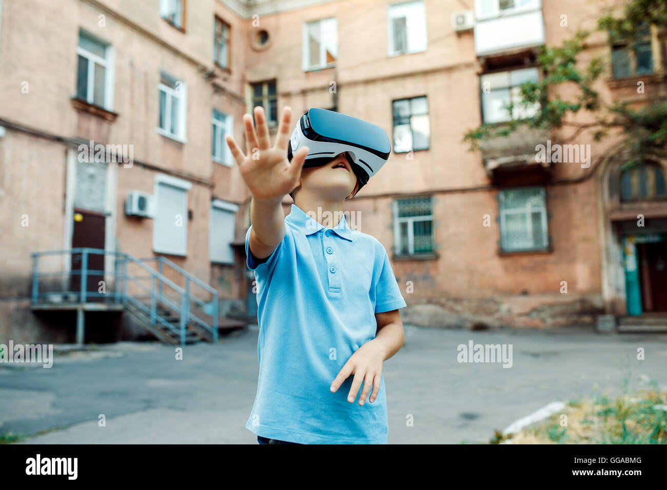 Fascinated little boy using VR virtual reality goggles. outdoor Stock ...