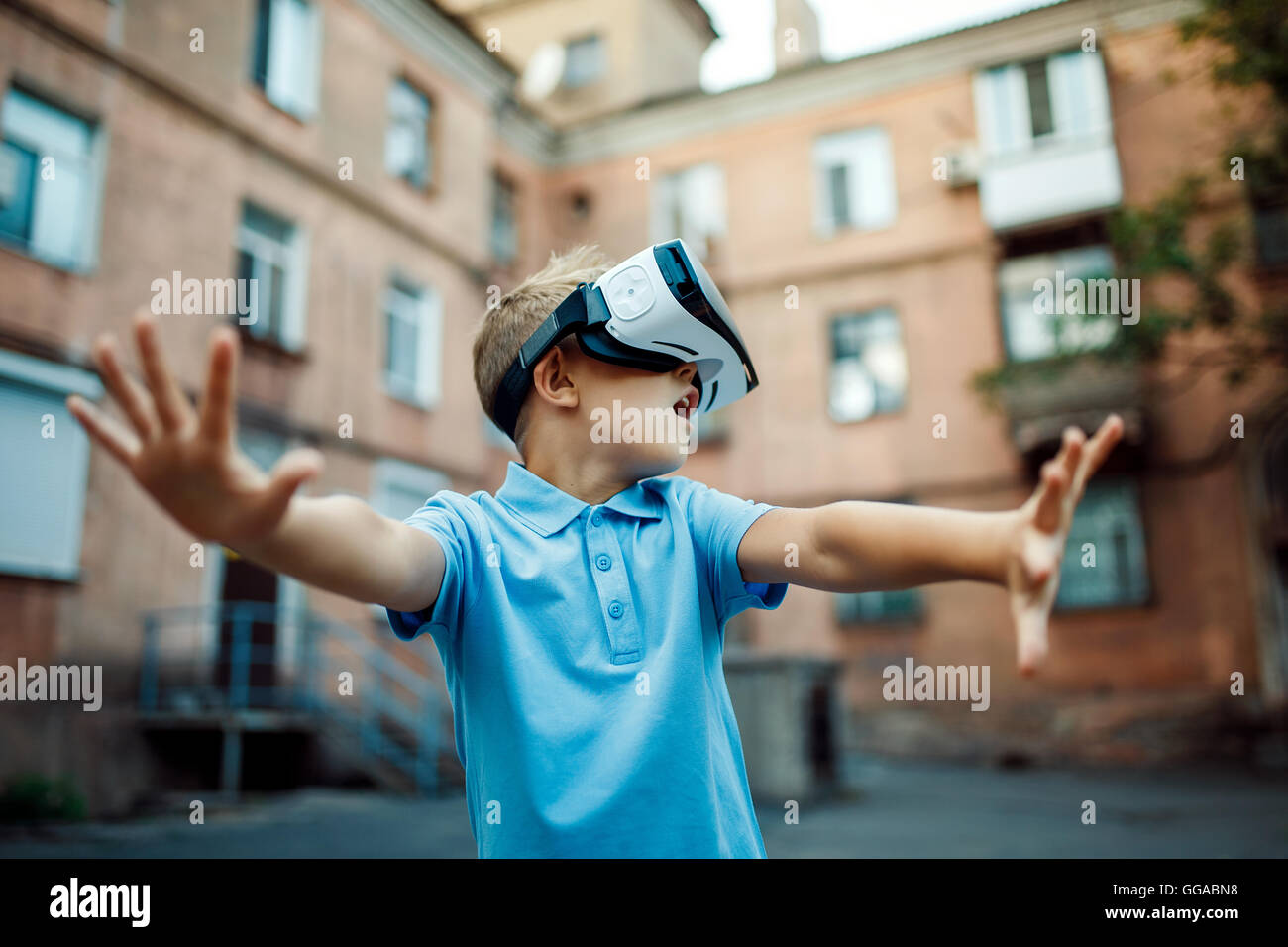 Fascinated little boy using VR virtual reality goggles. outdoor Stock ...