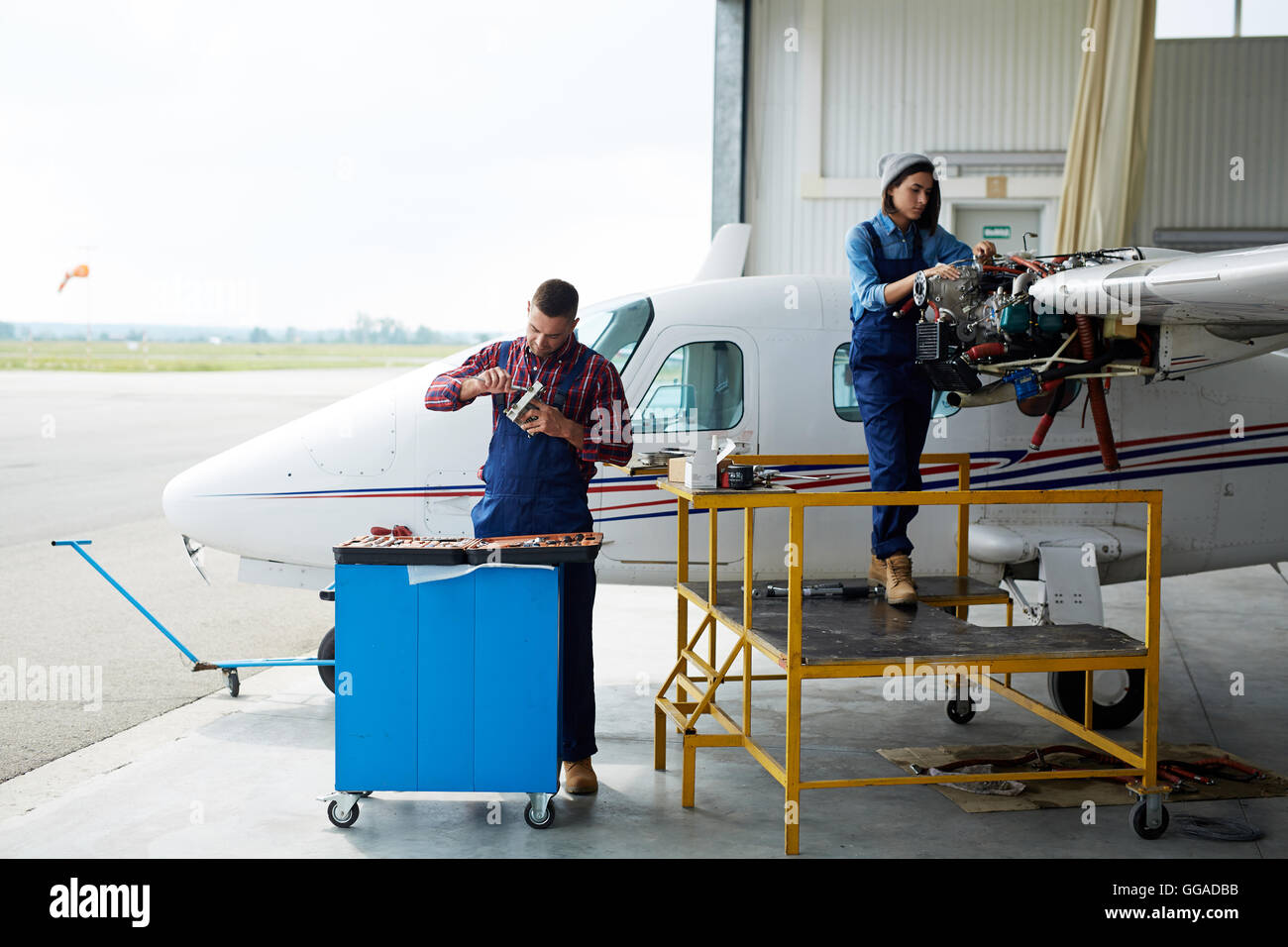 Engineers repairing airplane Stock Photo - Alamy