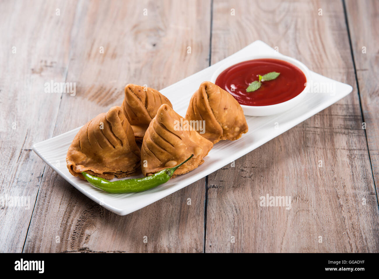 Samosa snack with tomato ketchup and hot tea, Fresh samosas with ...