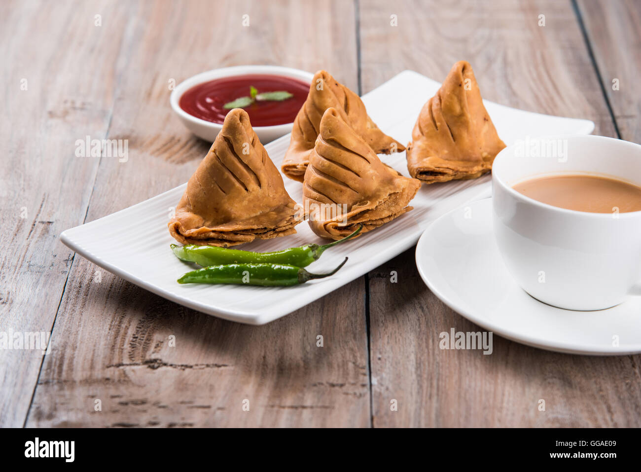 Samosa snack with tomato ketchup and hot tea, Fresh samosas with ...