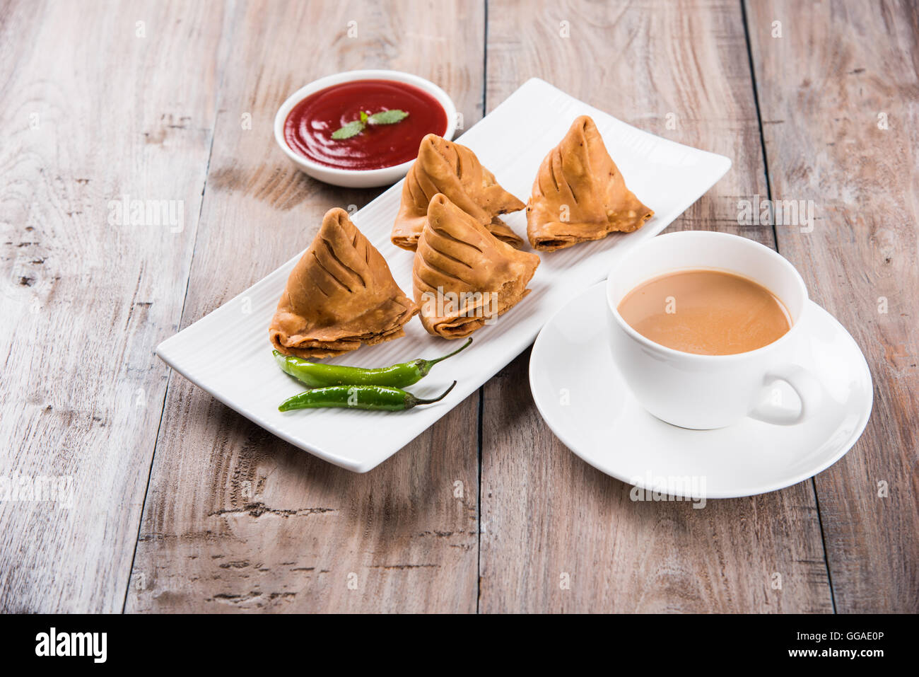 Samosa snack with tomato ketchup and hot tea, Fresh samosas with ...