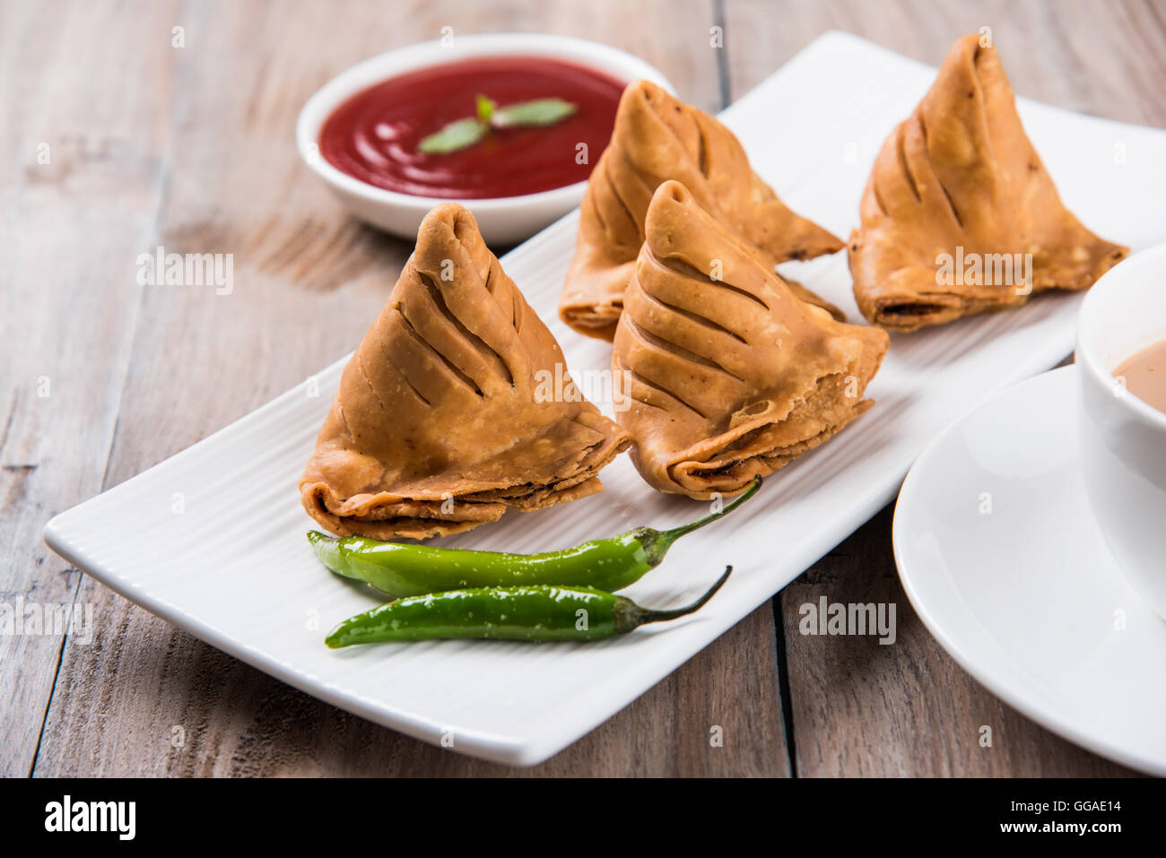 Samosa snack with tomato ketchup and hot tea, Fresh samosas with ...