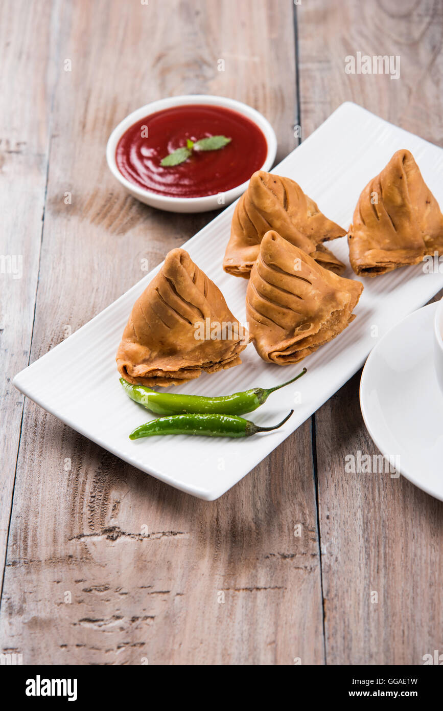 Samosa snack with tomato ketchup and hot tea, Fresh samosas with ...