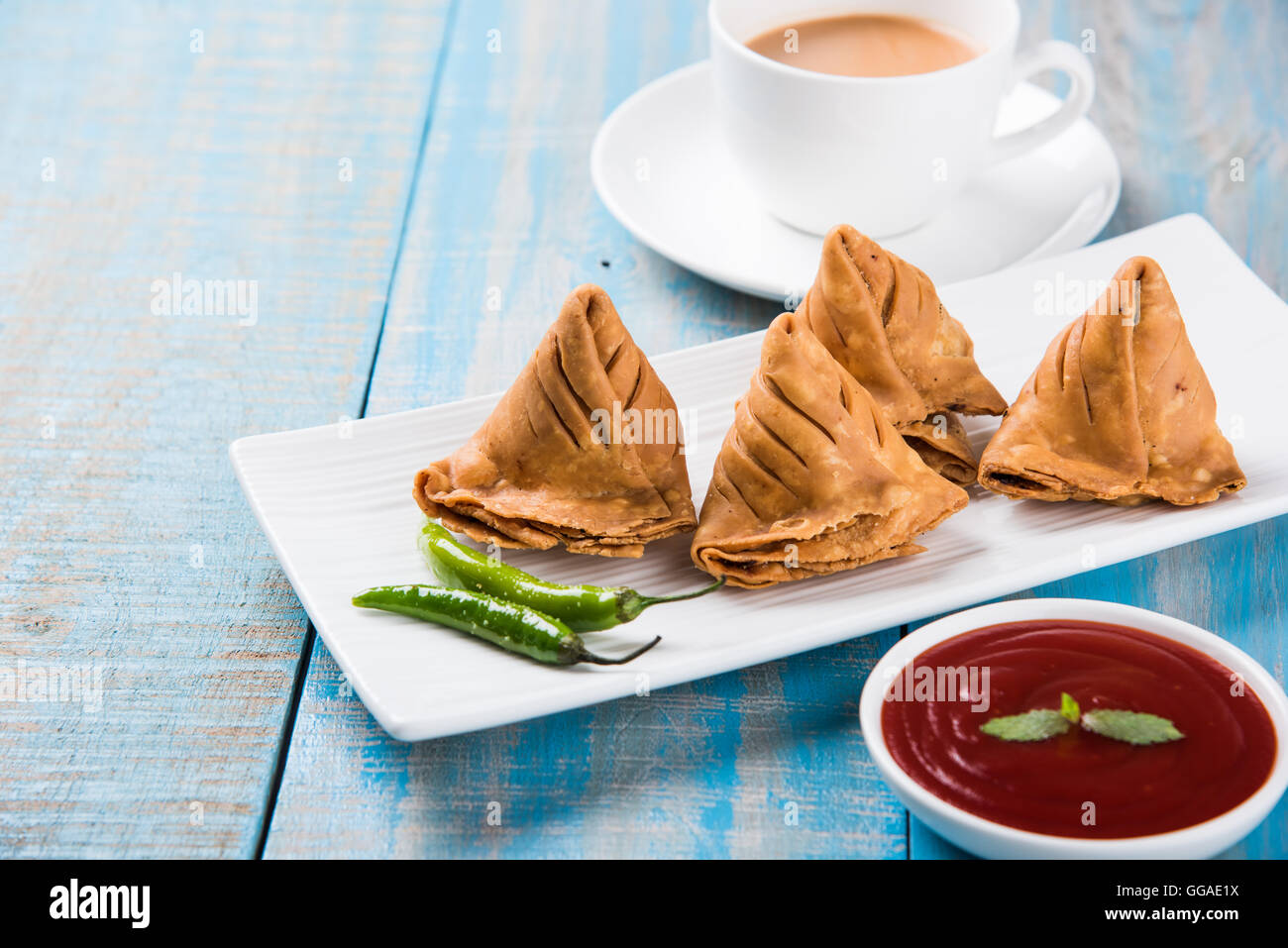 Samosa snack with tomato ketchup and hot tea, Fresh samosas with ...