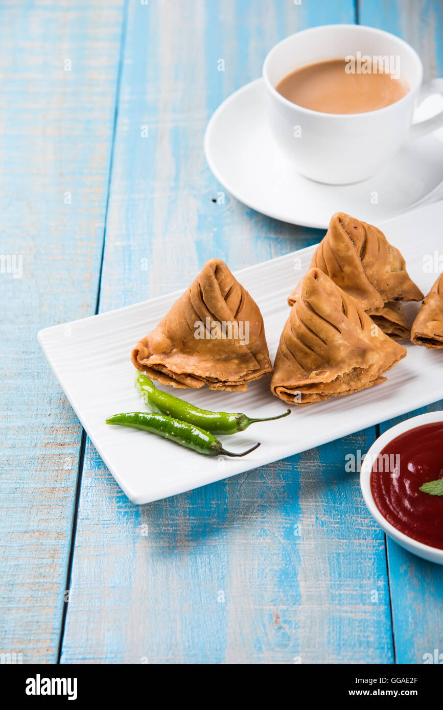 Samosa snack with tomato ketchup and hot tea, Fresh samosas with ...