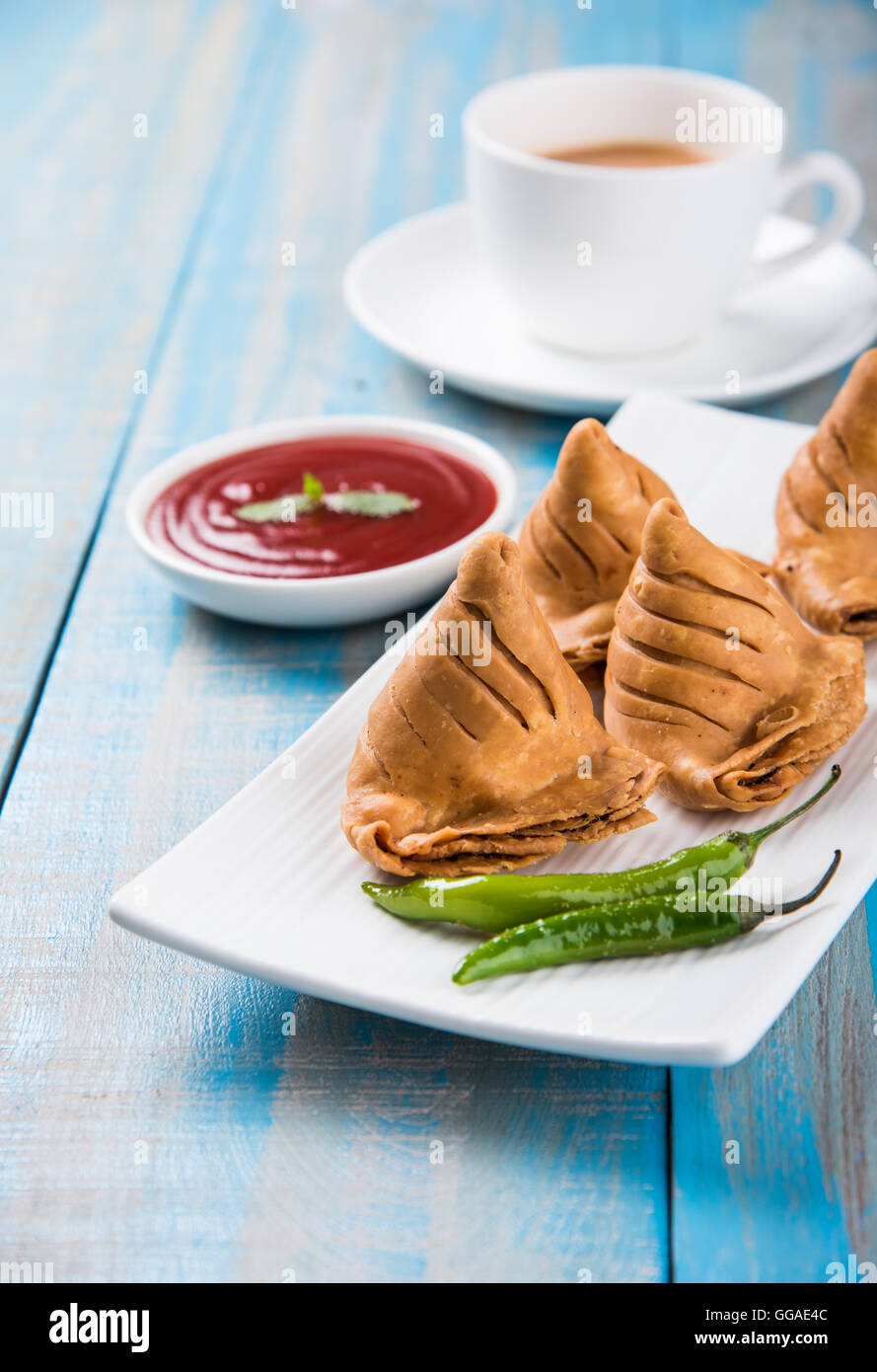Samosa snack with tomato ketchup and hot tea, Fresh samosas with ...