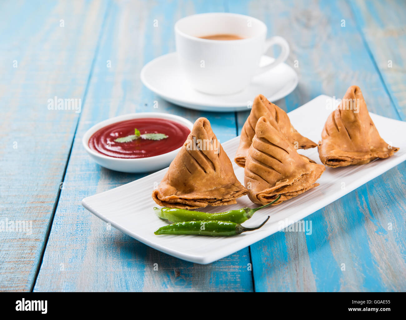 Samosa snack with tomato ketchup and hot tea, Fresh samosas with ...