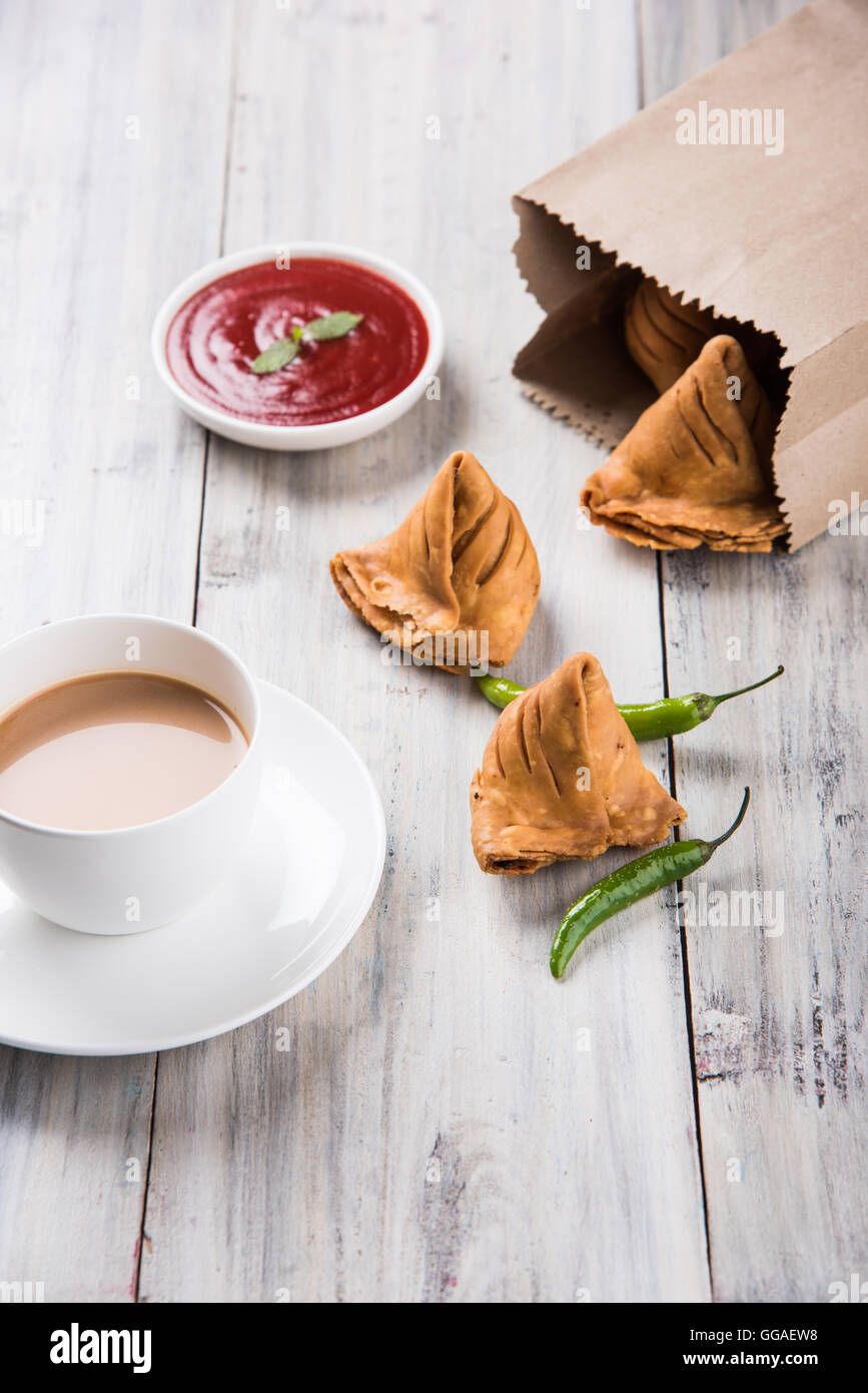 Samosa snack with tomato ketchup and hot tea, Fresh samosas with ...