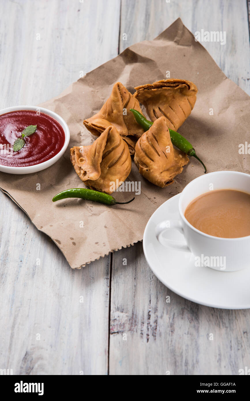 Samosa snack with tomato ketchup and hot tea, Fresh samosas with ...
