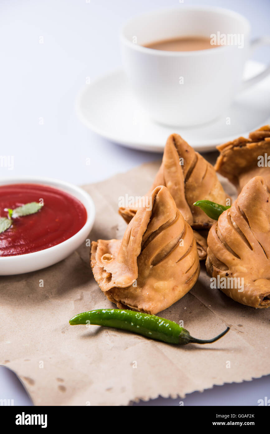 Samosa snack with tomato ketchup and hot tea, Fresh samosas with ...