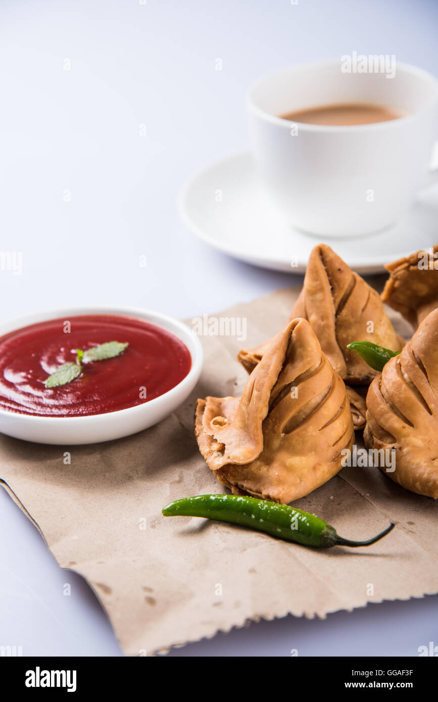 Samosa snack with tomato ketchup and hot tea, Fresh samosas with ...
