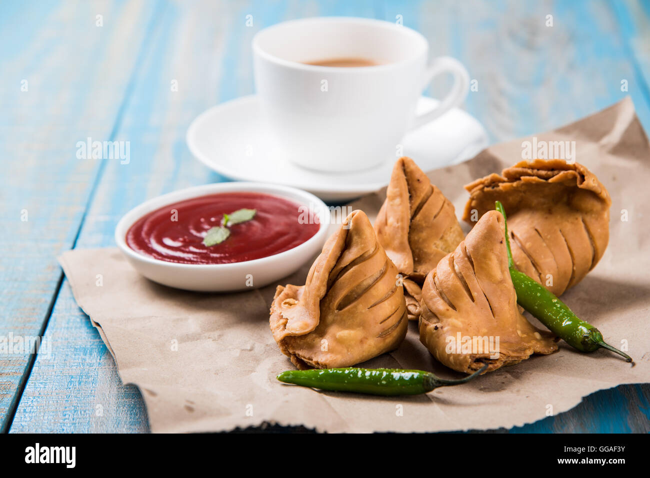 Samosa snack with tomato ketchup and hot tea, Fresh samosas with ...