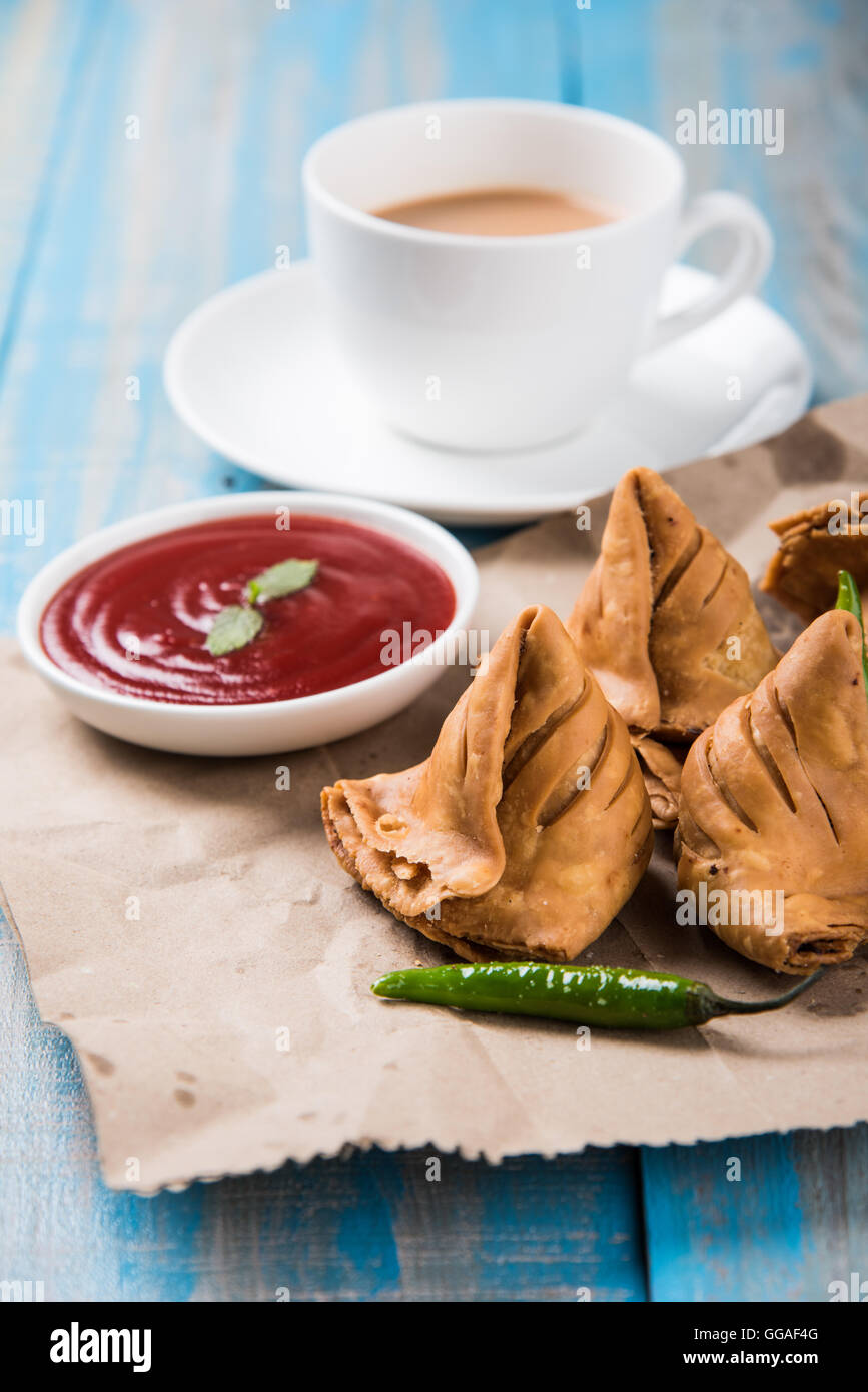 Samosa snack with tomato ketchup and hot tea, Fresh samosas with ...