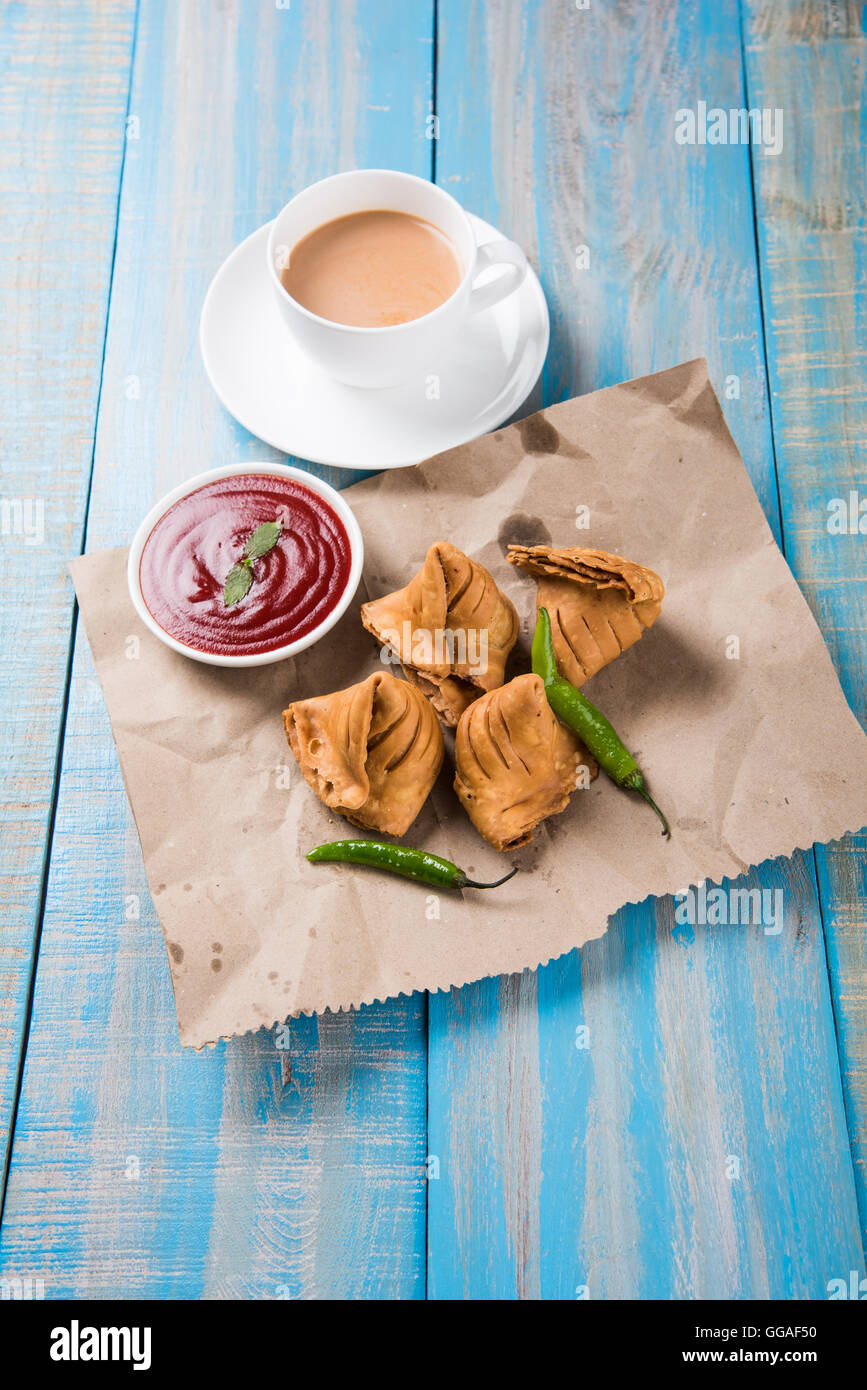 Samosa snack with tomato ketchup and hot tea, Fresh samosas with ...