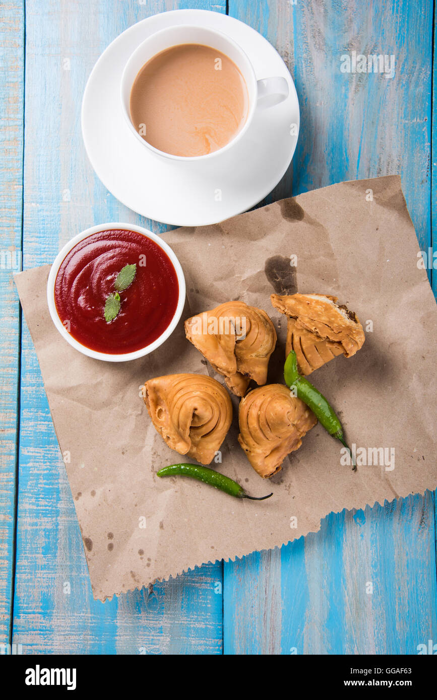 Samosa snack with tomato ketchup and hot tea, Fresh samosas with ...