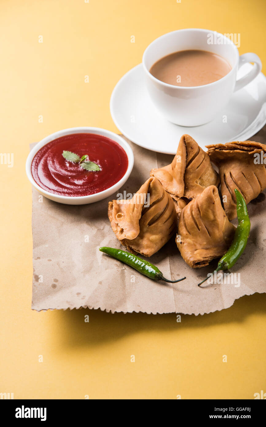 Samosa snack with tomato ketchup and hot tea, Fresh samosas with ...