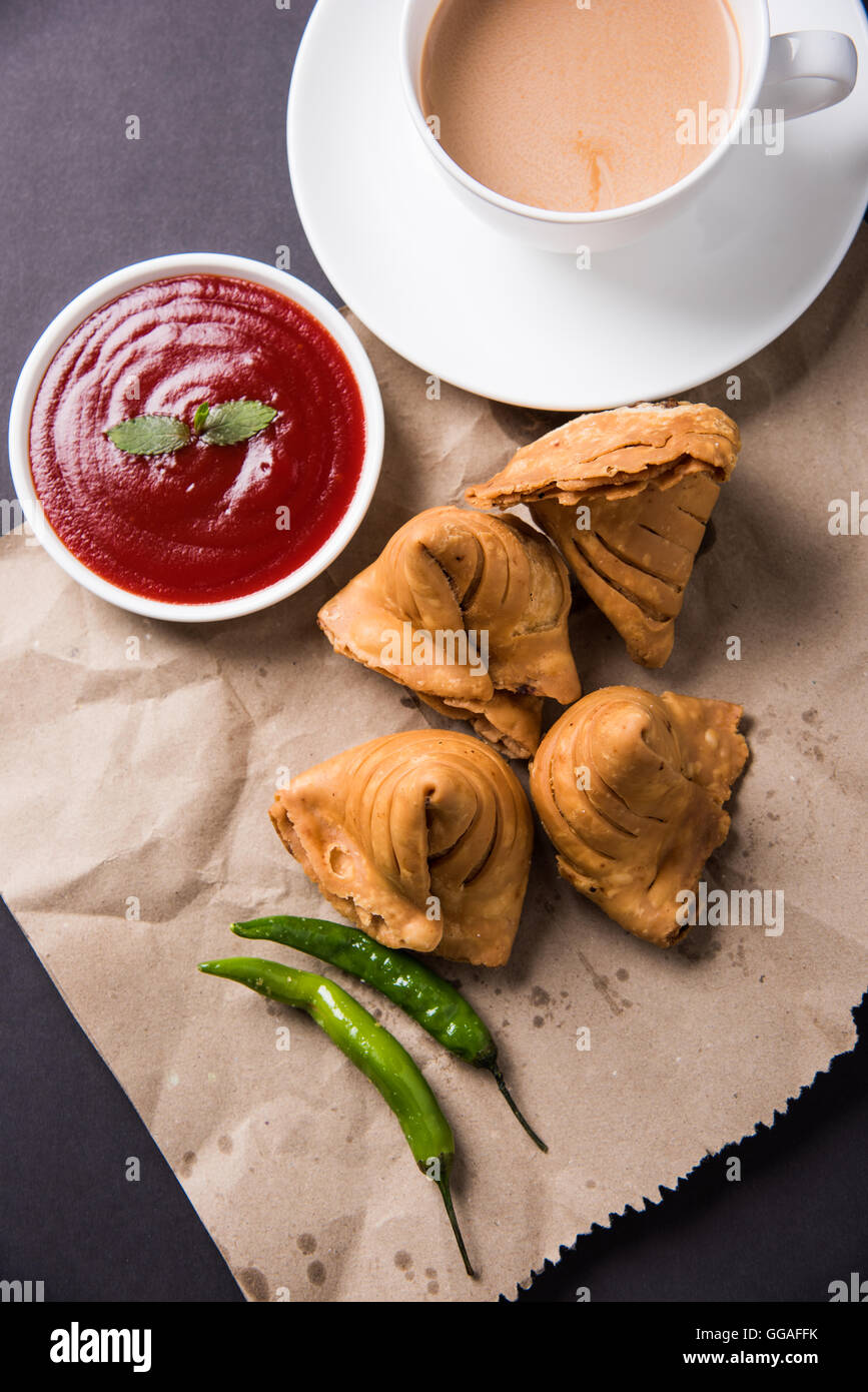 Samosa snack with tomato ketchup and hot tea, Fresh samosas with ...