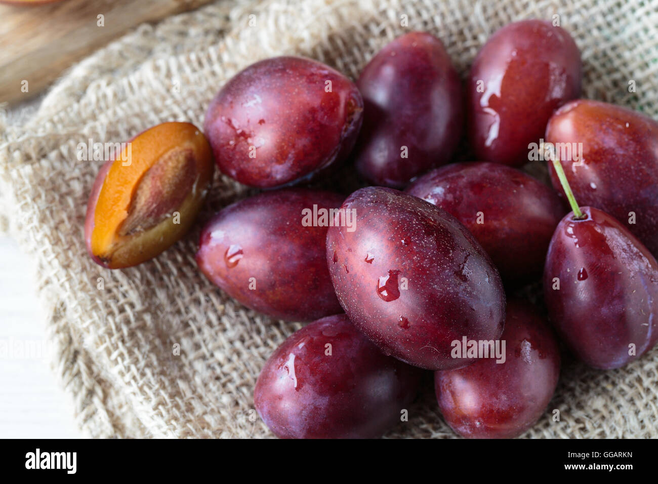 Bunch of fresh purple plums on jute cloth Stock Photo - Alamy