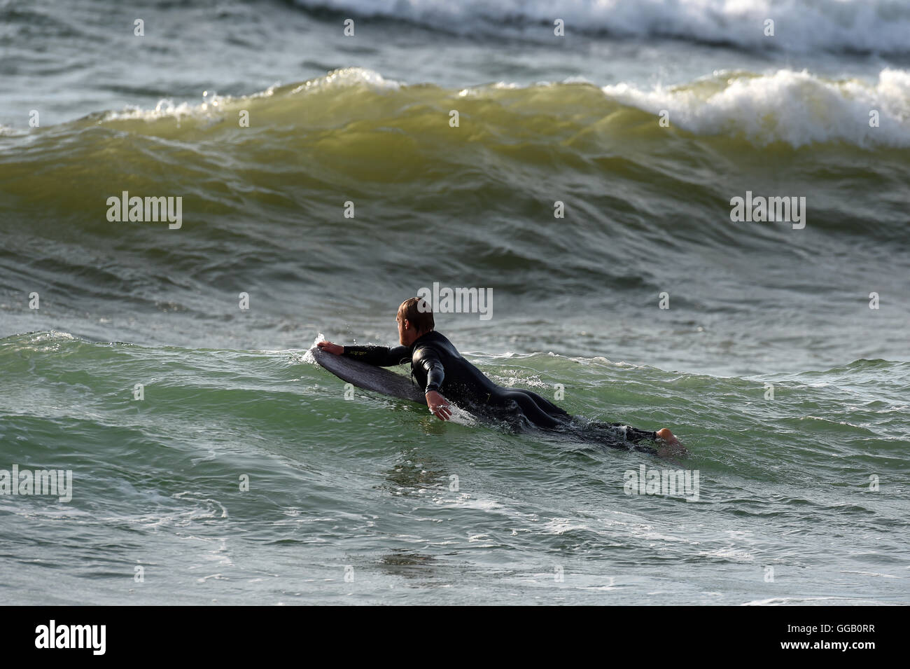 Surfer paddling out into the waves hi-res stock photography and images ...