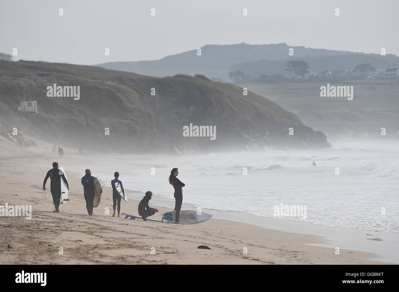 Surfers on the beach watching the wave sets Stock Photo - Alamy
