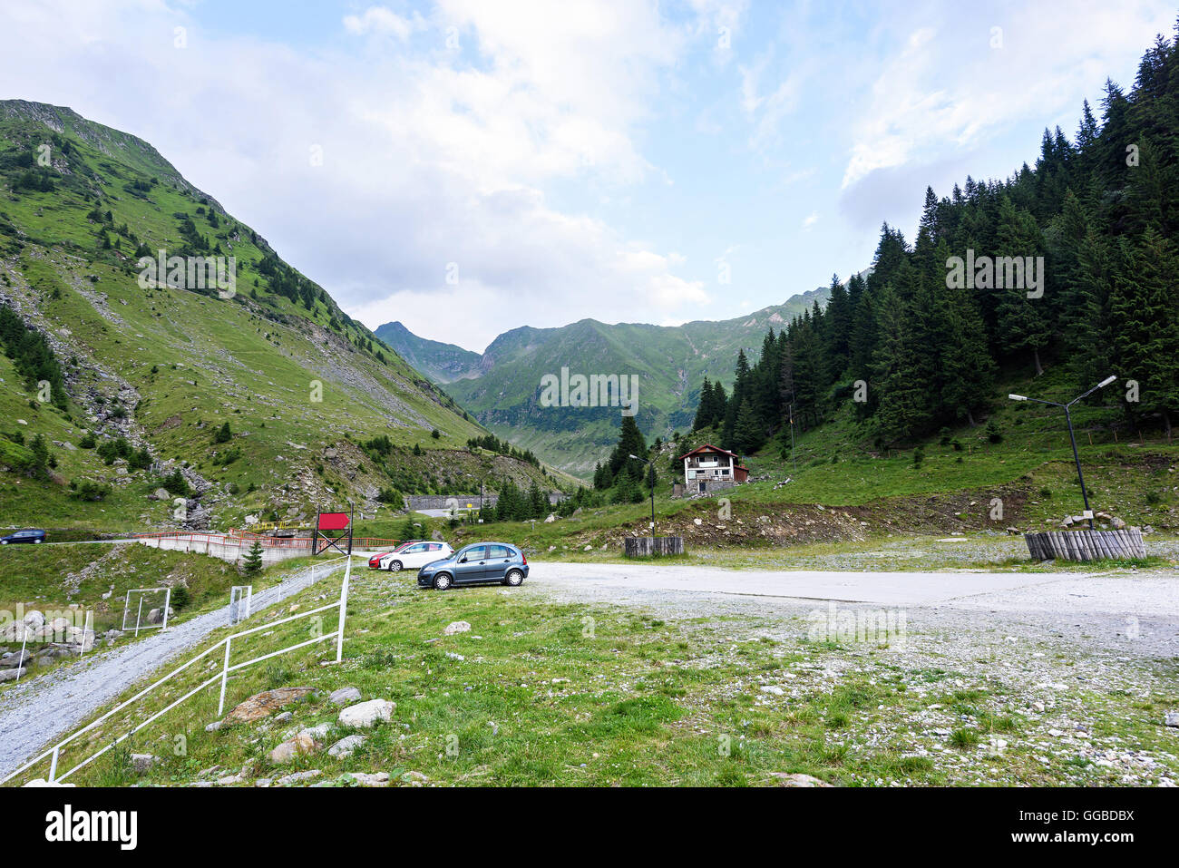Photo of green capra peak, a small river and a road in fagaras ...
