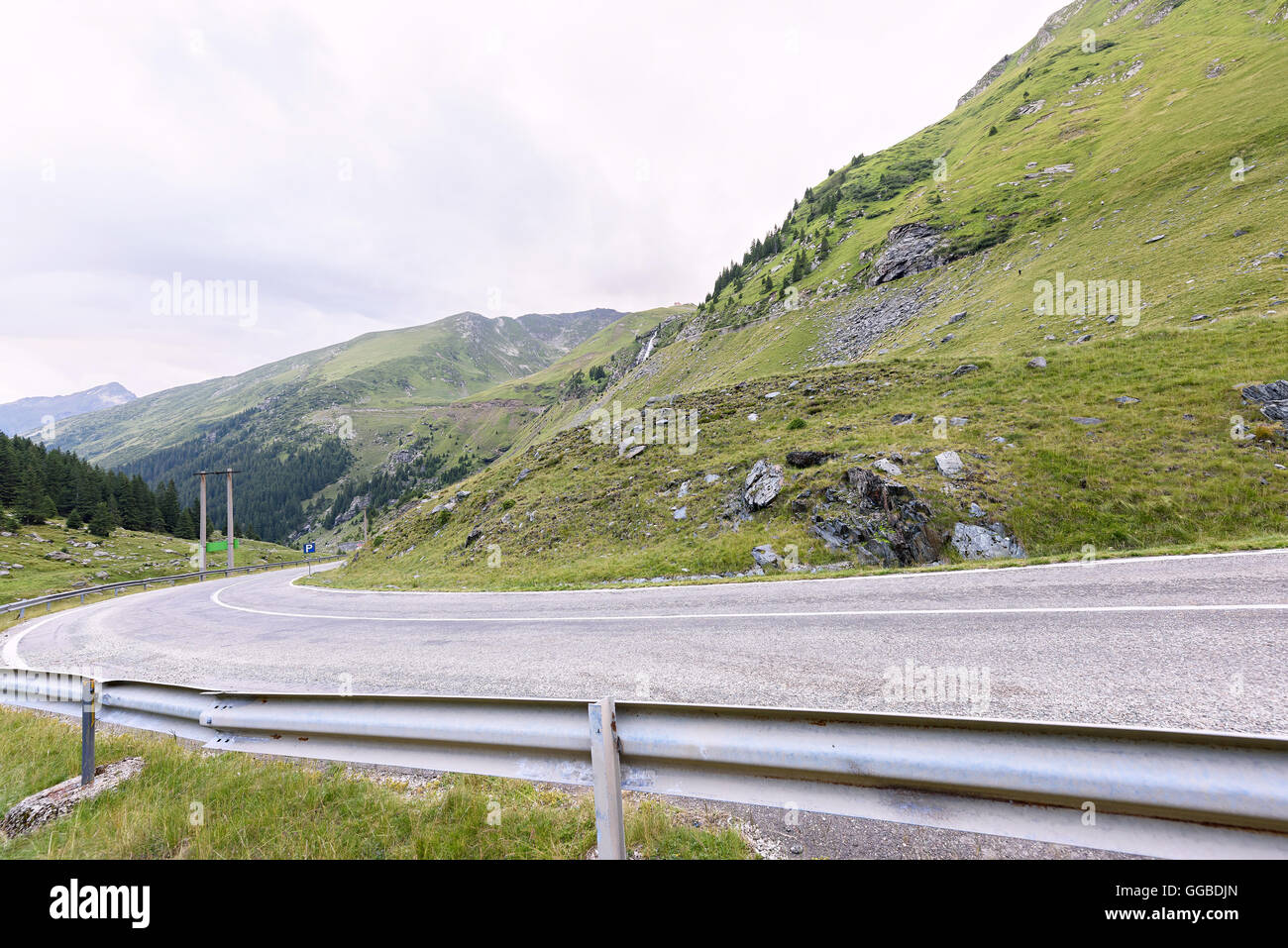 Photo of green capra peak, a road and a small river in fagaras ...