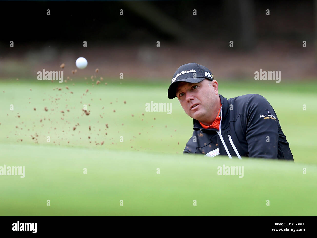 Graeme Storm chips out of the bunker on the 11th green during day one ...