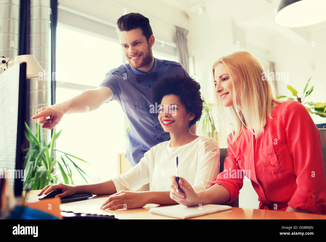 happy creative team with computer in office Stock Photo - Alamy