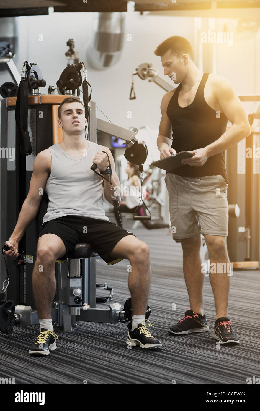 man exercising on gym machine Stock Photo - Alamy