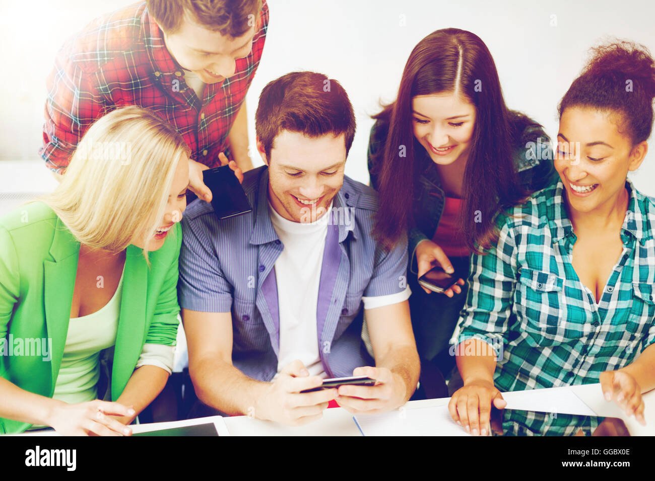 students looking into smartphone at school Stock Photo - Alamy
