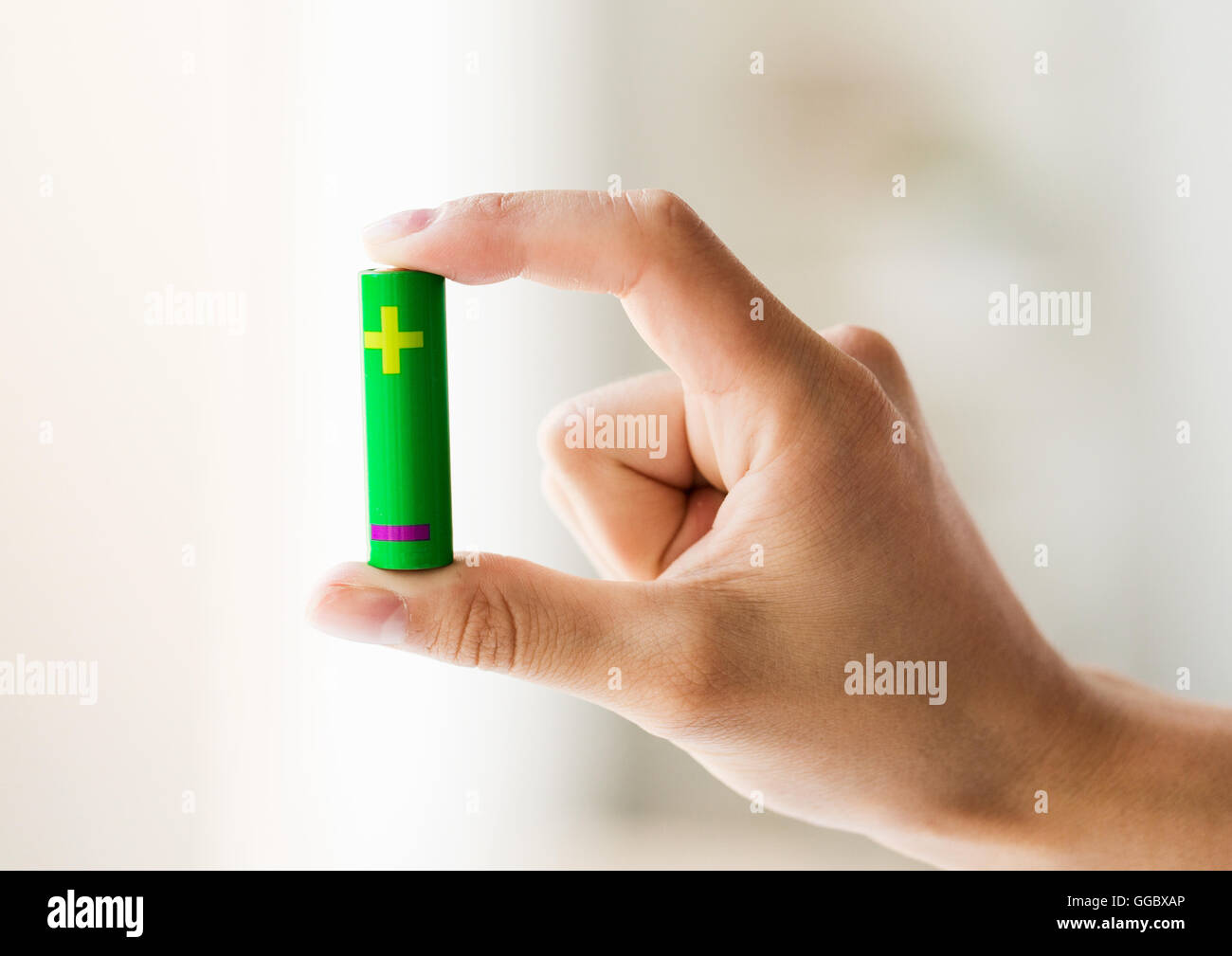 close up of hand holding green alkaline battery Stock Photo - Alamy