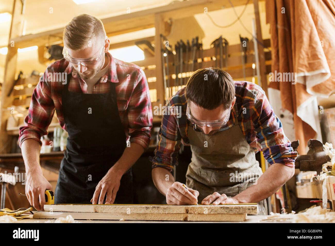 carpenters with ruler and wood plank at workshop Stock Photo - Alamy