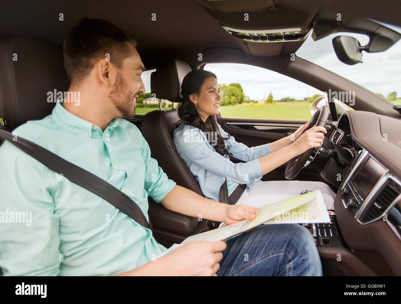 happy man and woman with road map driving in car Stock Photo - Alamy
