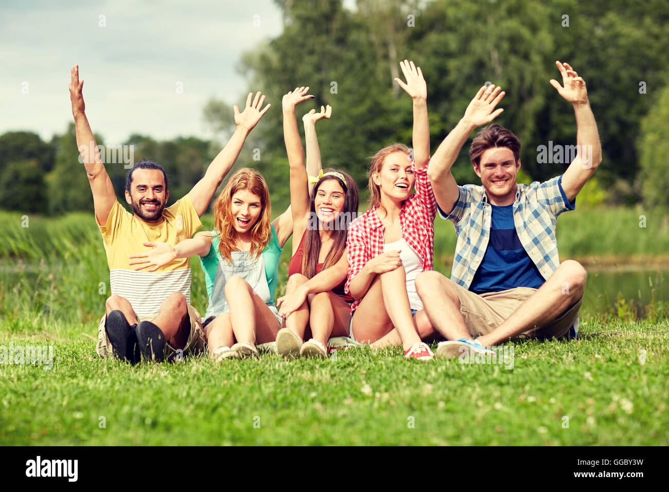 Woman waving at sitting friends hi-res stock photography and images - Alamy