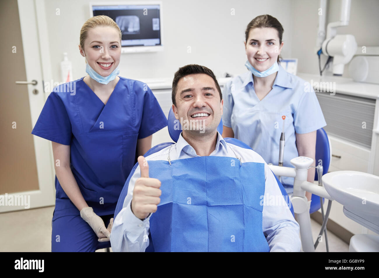 happy female dentists with man patient at clinic Stock Photo - Alamy