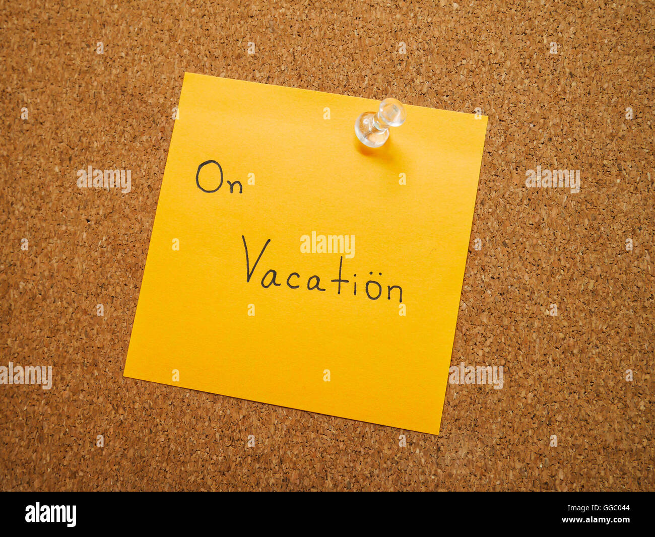 Text on vacation in orange post note and pin attach on wood board Stock ...