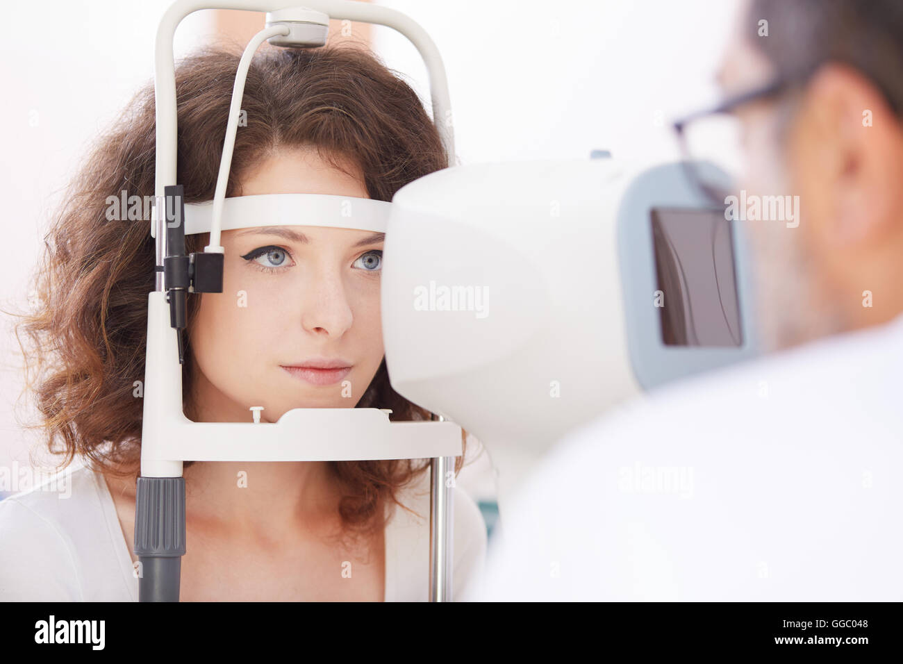 pretty young optometrist at work, examinating your eyes Stock Photo - Alamy