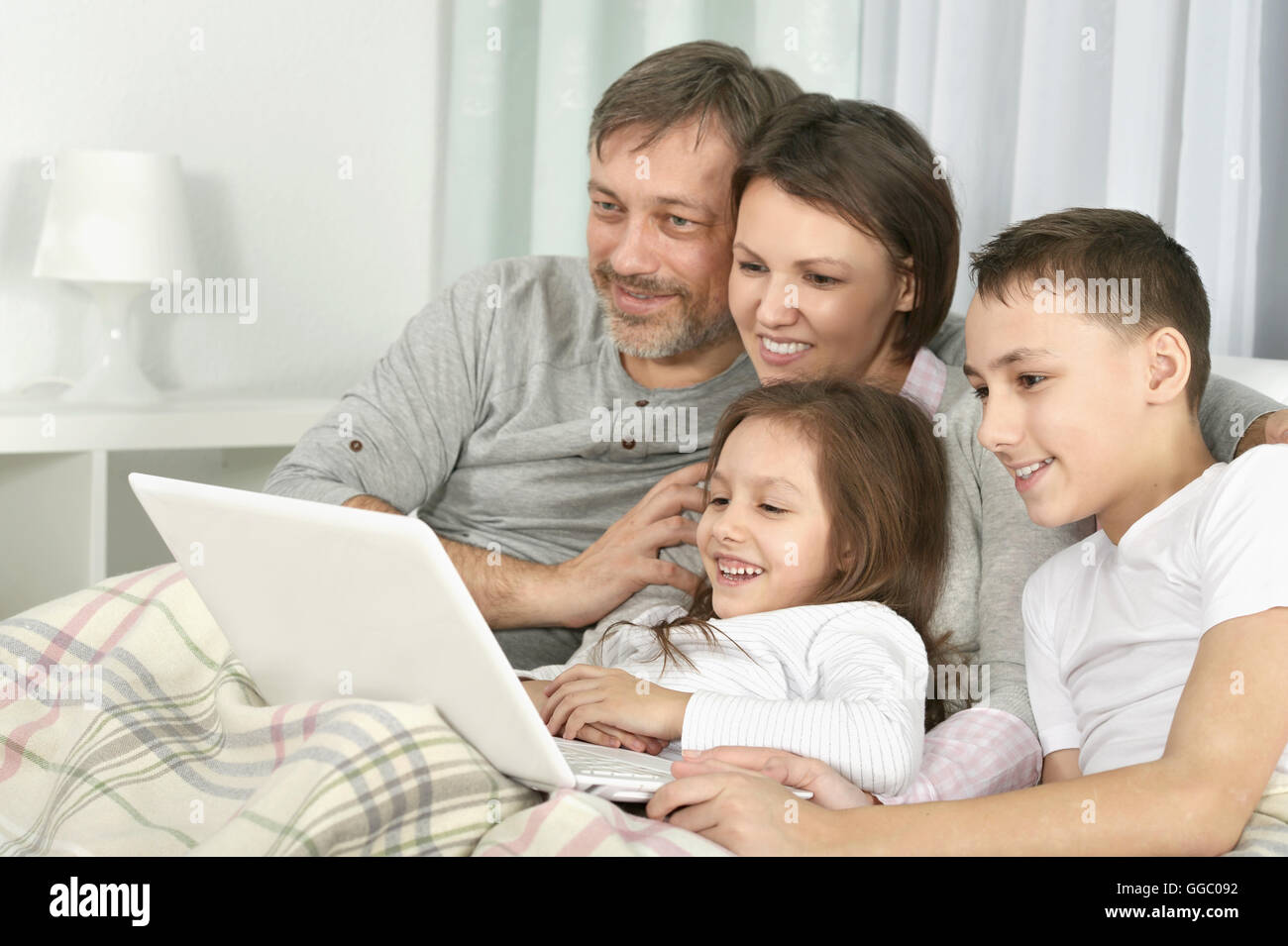 Happy family with laptop Stock Photo - Alamy