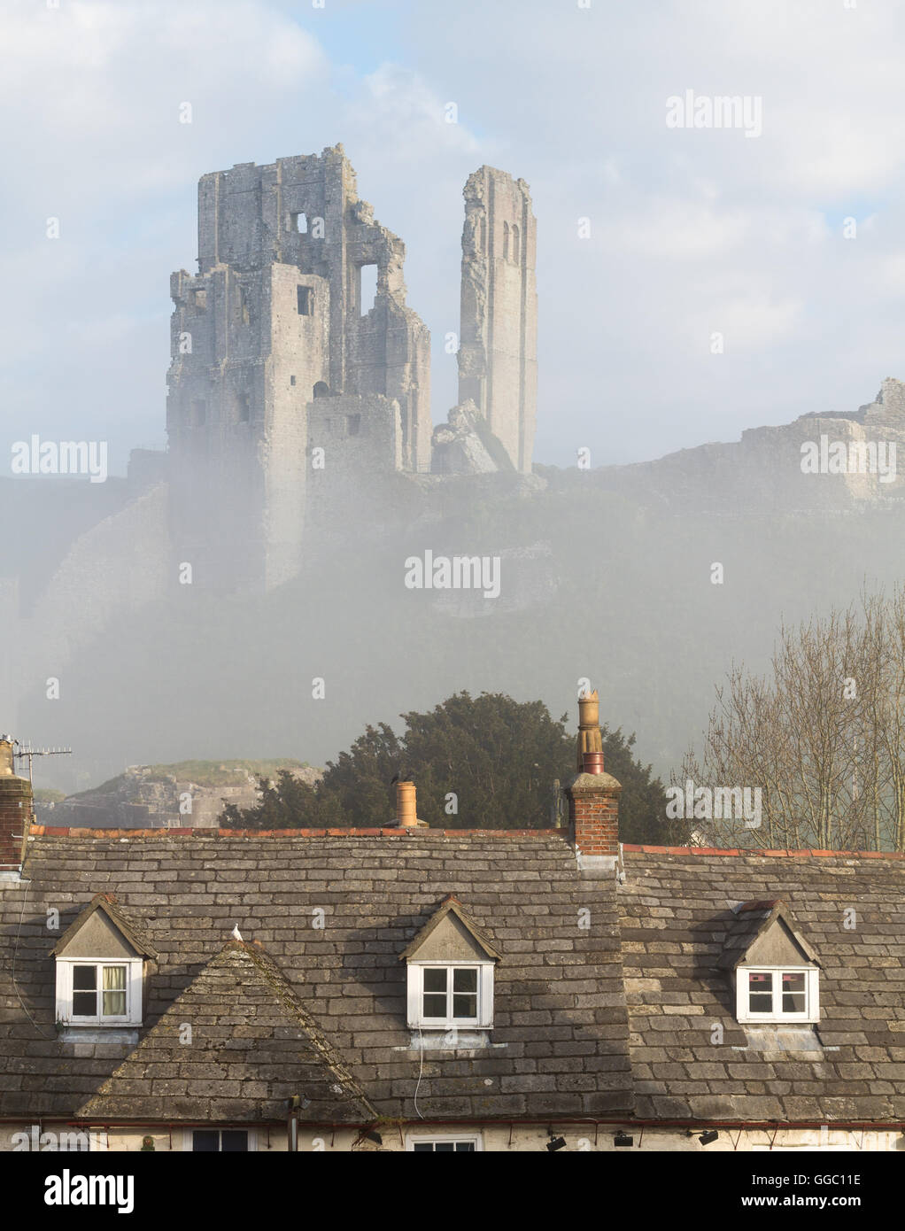 hotel pub and castle ruin roof with morning mist fog on sunny day with ...