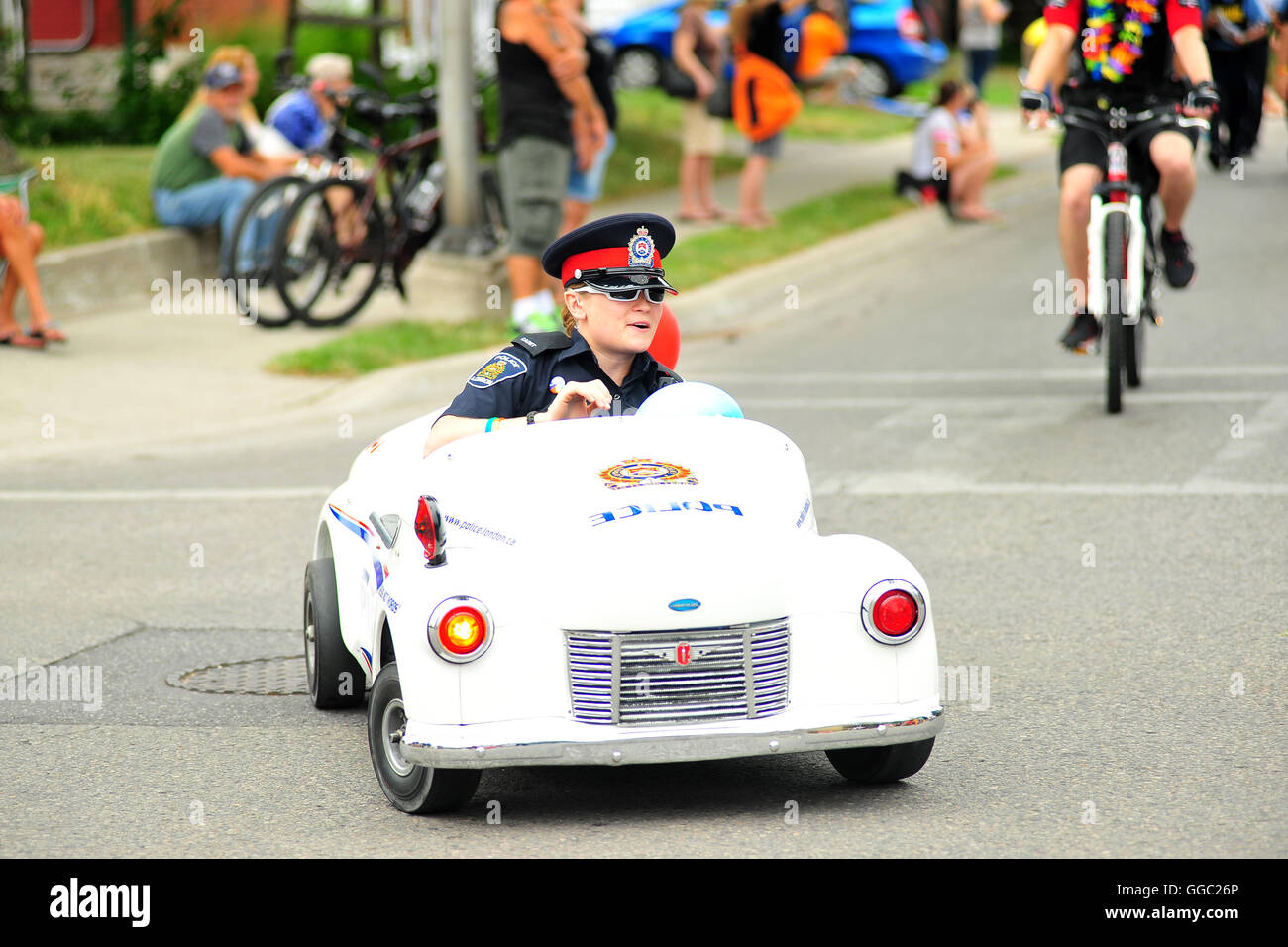 A police officer drives a small police car at a Pride event in the ...