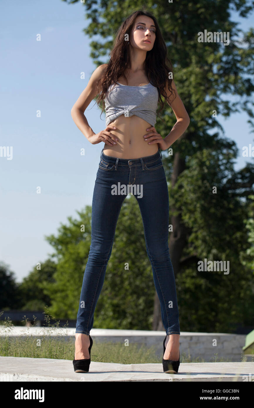 Tall, slim model in blue jeans on the background of blue sky Stock ...