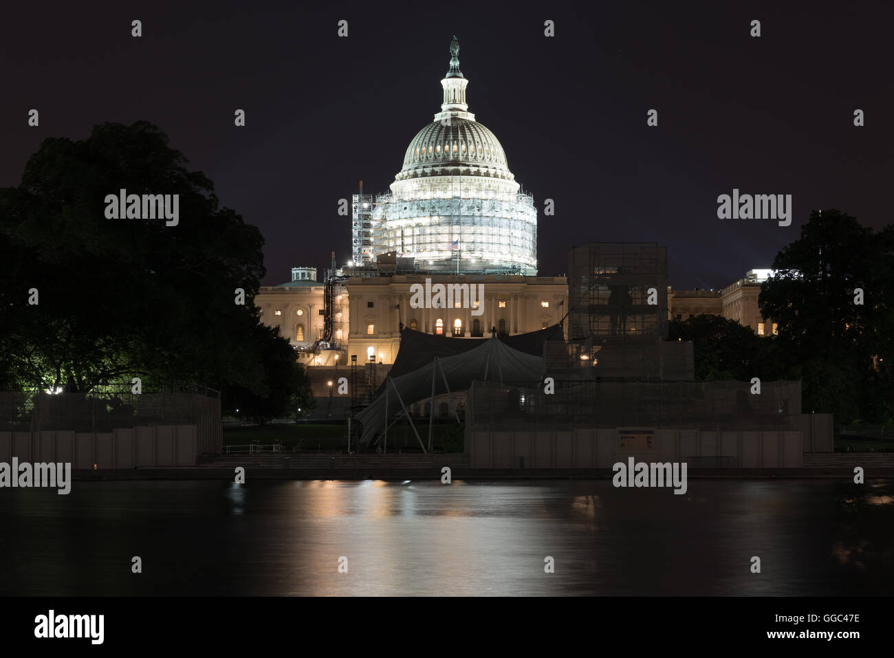 The US Capitol Building under scaffolding as seen across the reflecting ...