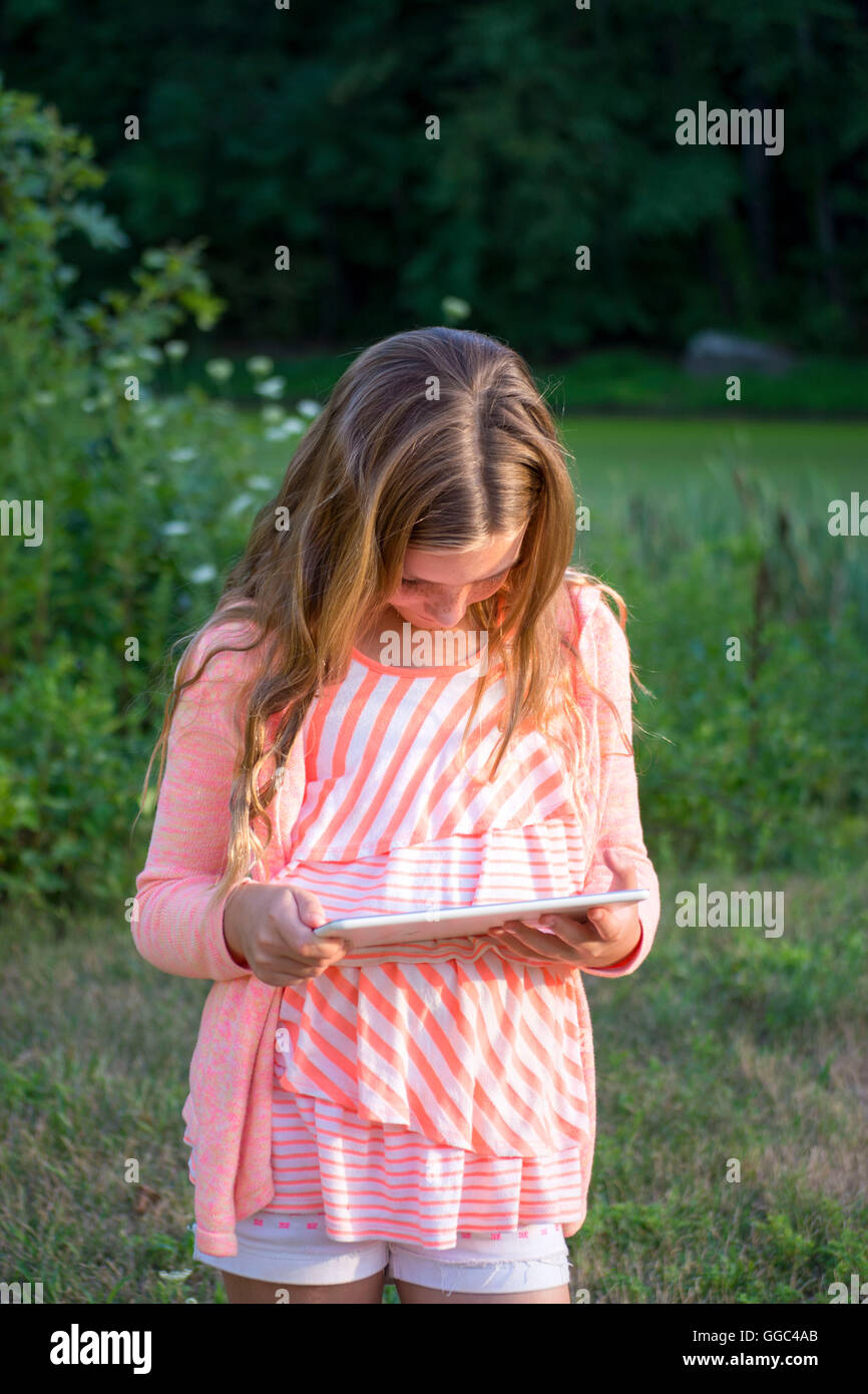 Child with tablet looking down Stock Photo - Alamy