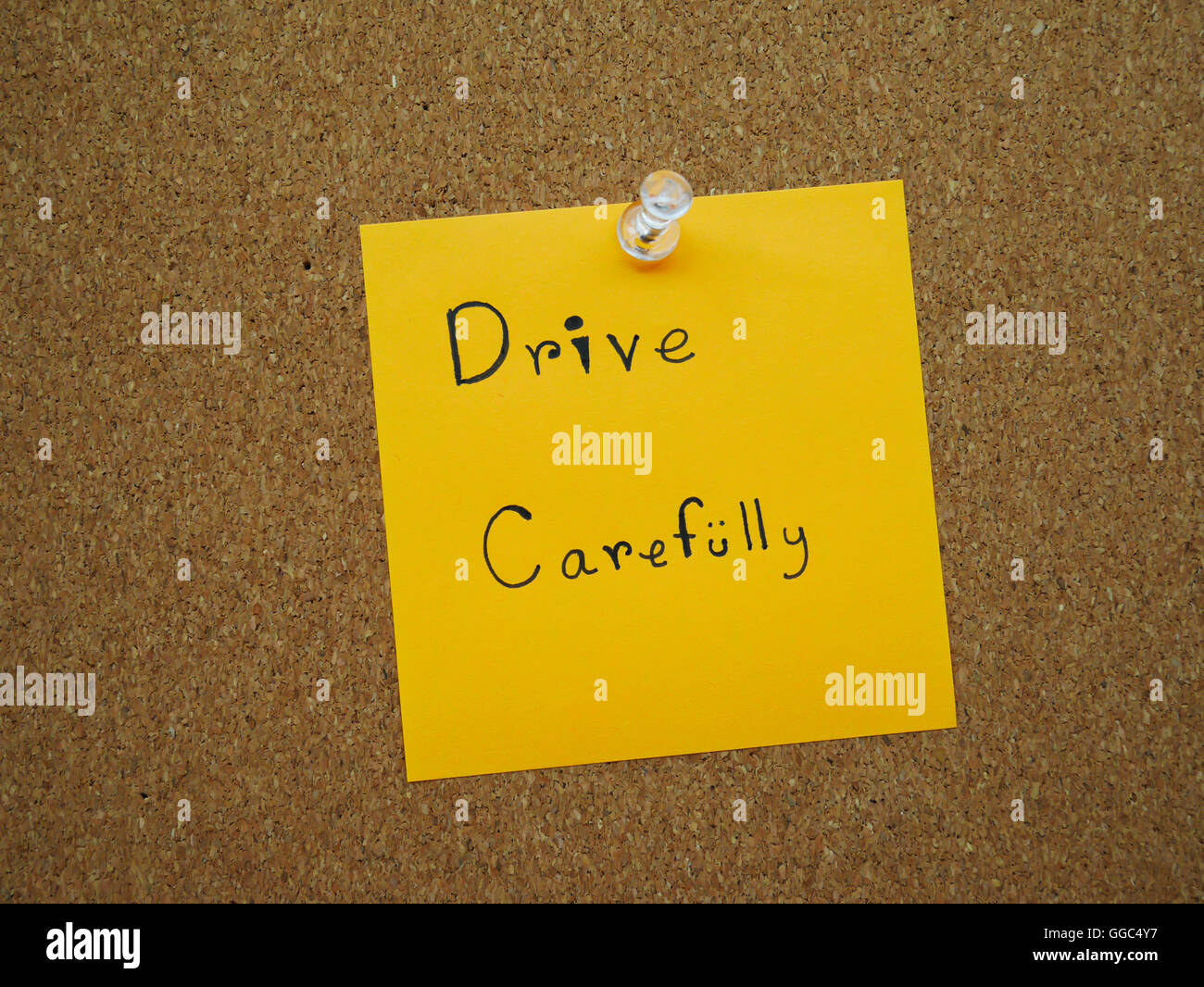 Drive carefully in post note on wooden board Stock Photo - Alamy