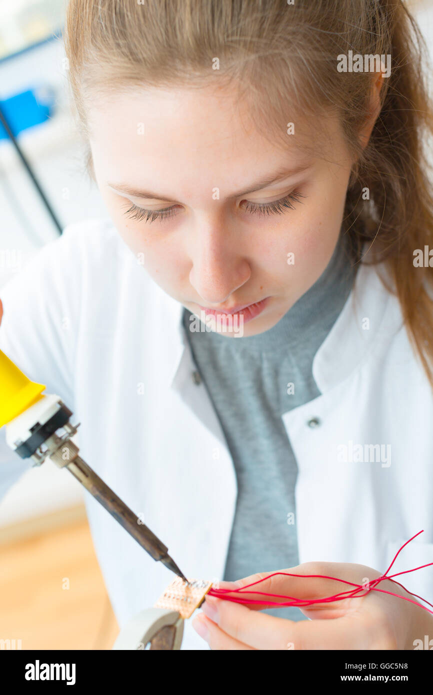 Woman with a soldering iron Stock Photo - Alamy